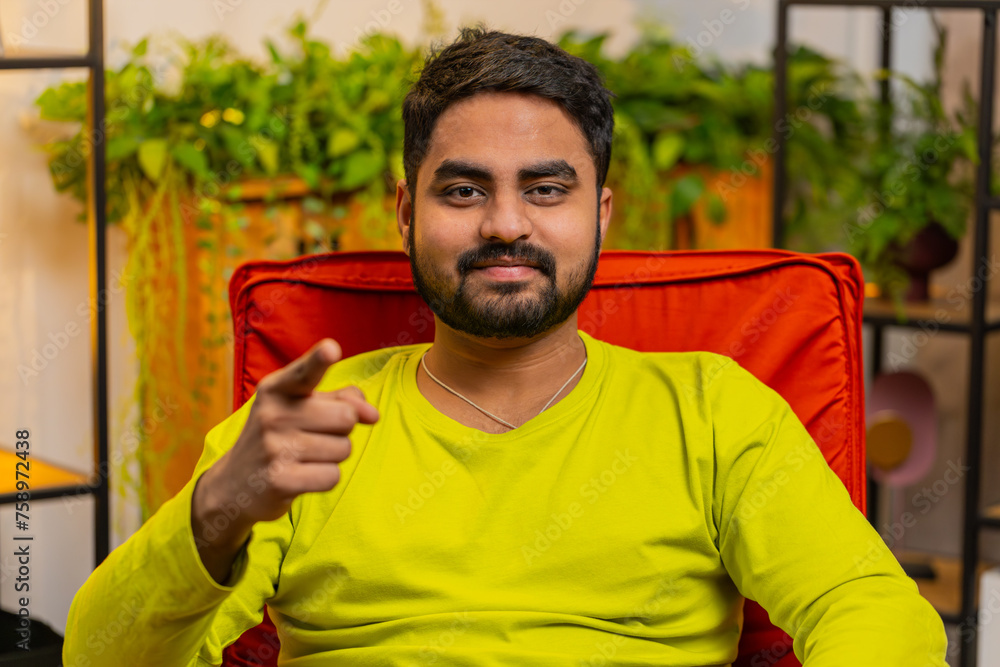 Hey you. Happy satisfied Indian man smiling excitedly and pointing to ...