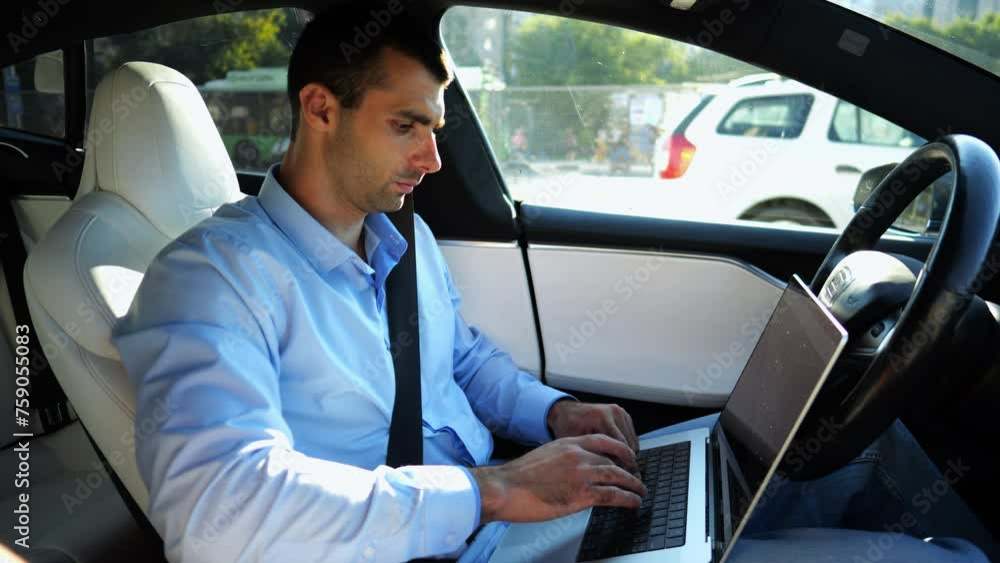 Handsome entrepreneur working on notebook while riding an autonomous ...