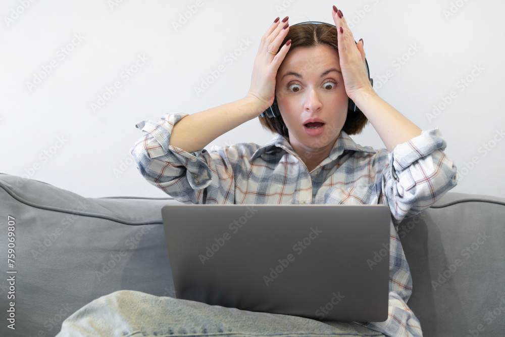 Shocked woman holding laptop. Surprised and upset girl looking at her ...