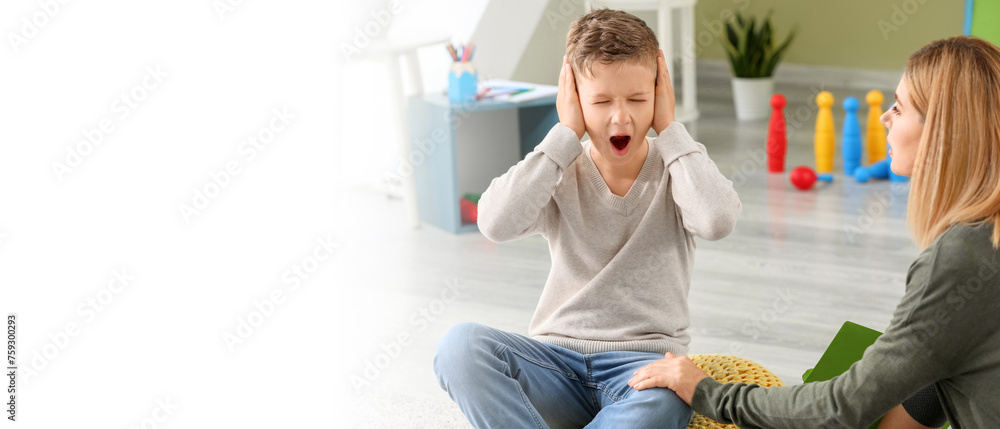 Female psychologist working with boy suffering from autistic disorder ...