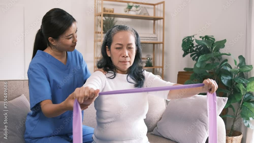 Beautiful Asian physical therapist is helping an elderly female patient ...