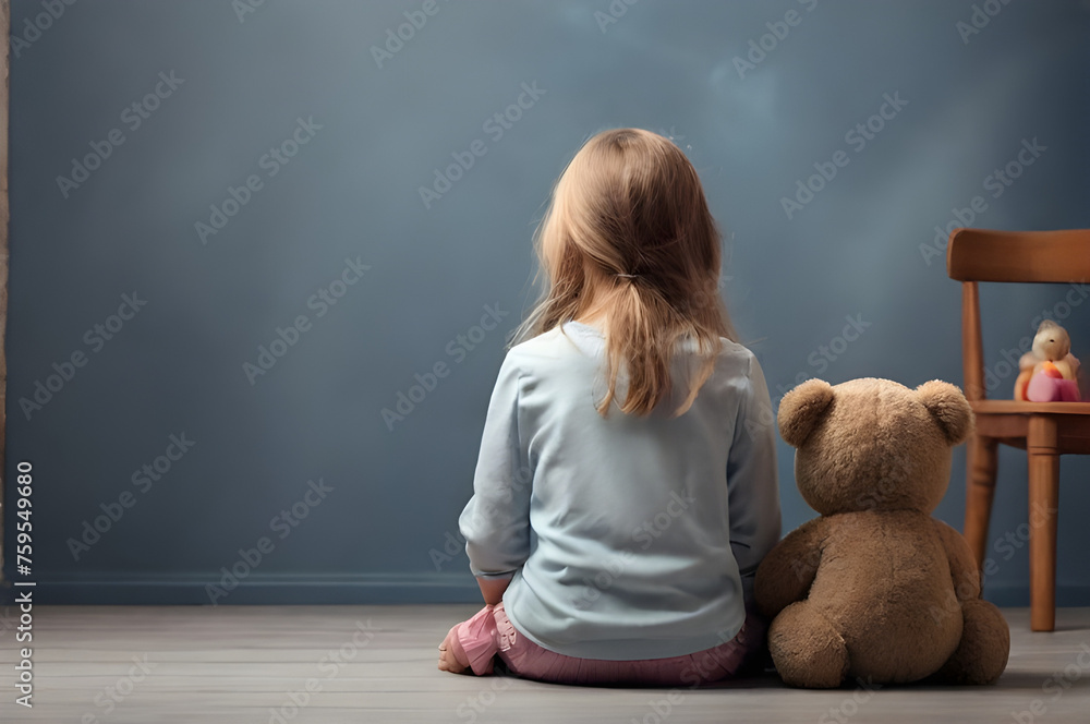 Back view of an upset lonely bullied little girl sitting on floor with ...