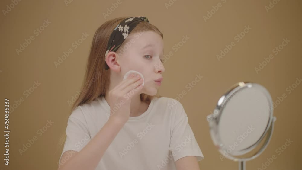 Cute teenage girl using facial spray and cotton pad to cleanse and ...