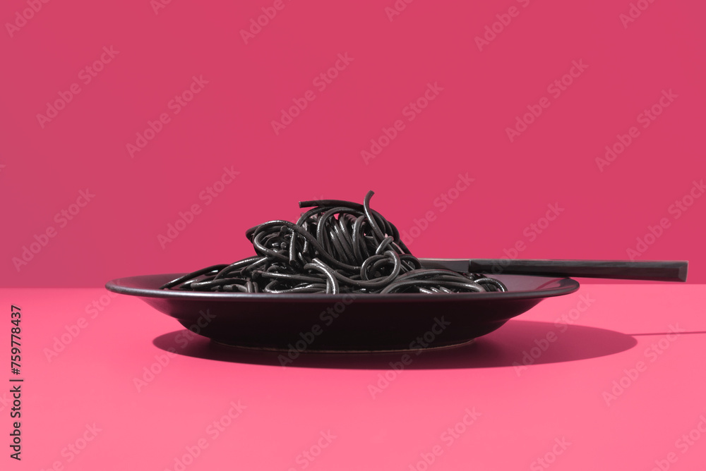 Espaguetis con tinta de calamar negro en un plato con tenedor sobre ...