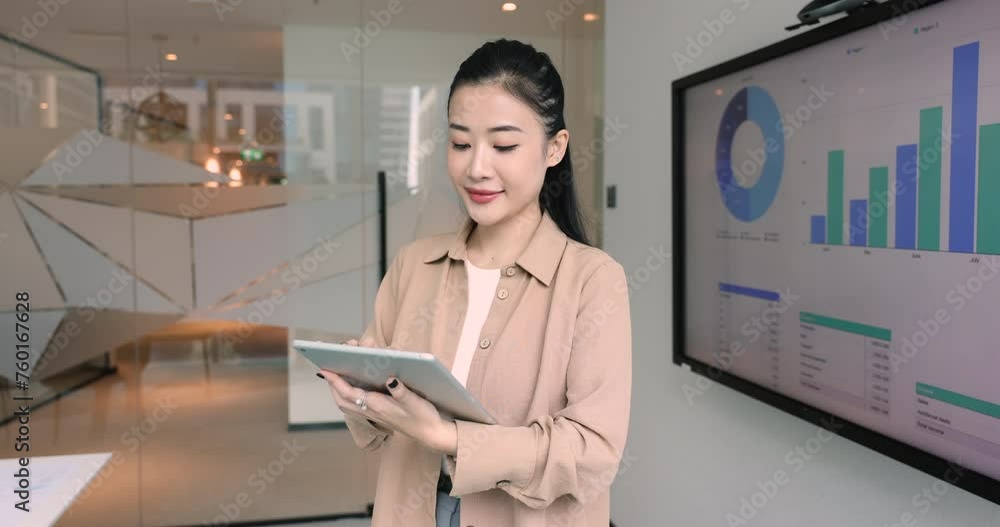 Attractive Asian businesswoman analyst standing in office near display ...