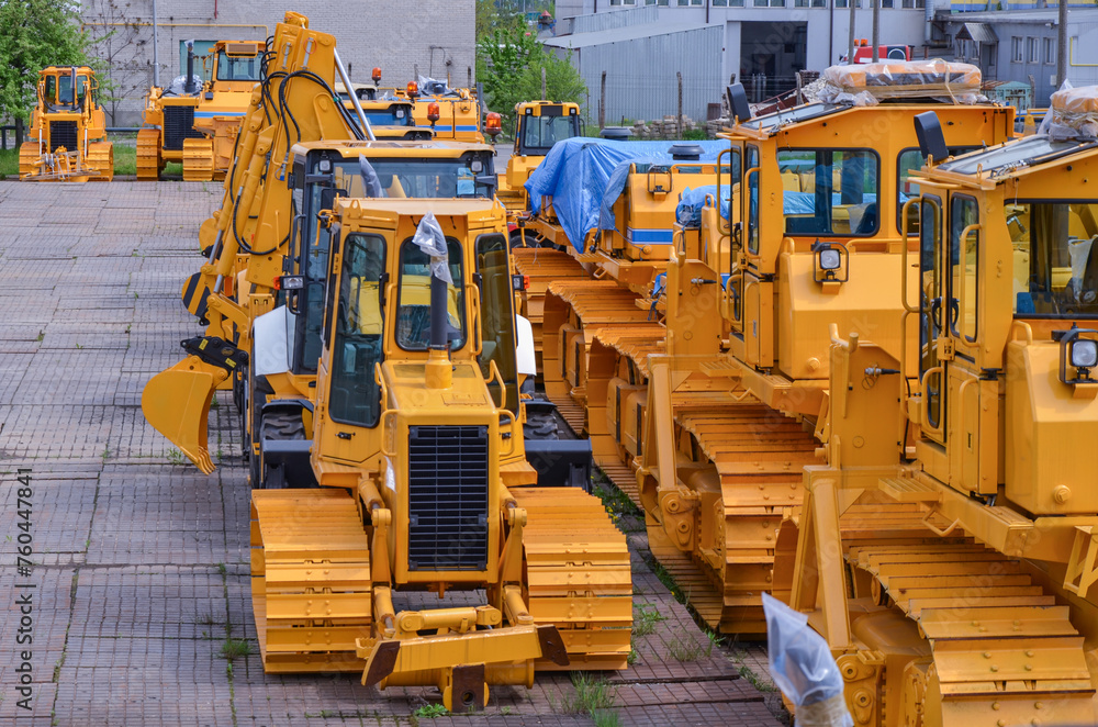 A storage yard with a lot of construction machines. Warehouse of ...