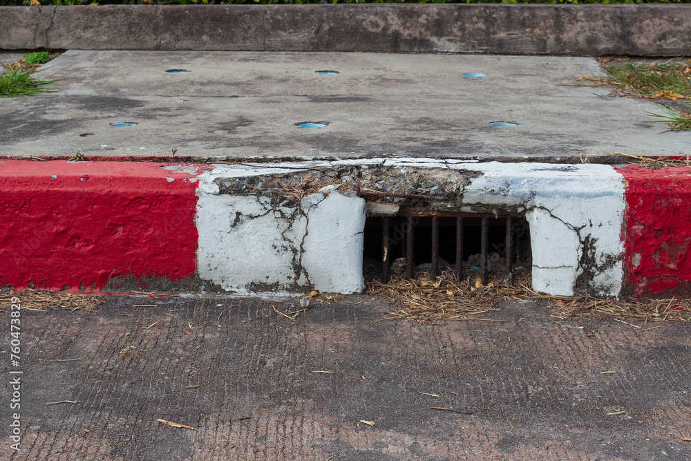 Rusty steel drainage grate among red and white broken side stone ...