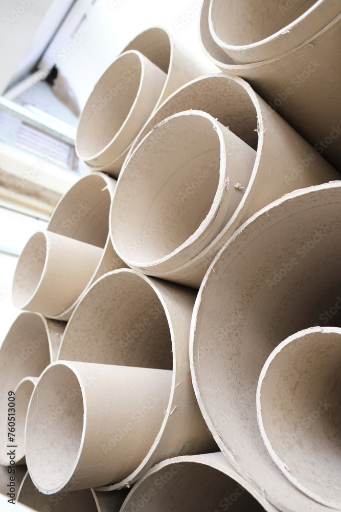 An industrial stack of empty paper cardboard tube rolls waiting to be ...