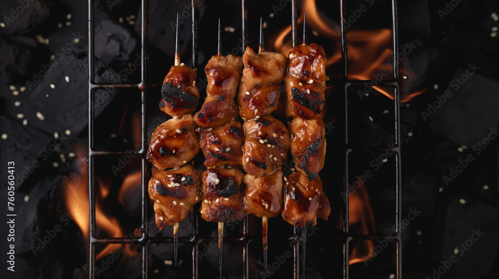 top downJapanese style Chicken Yakitori sits on black grill rack over ...