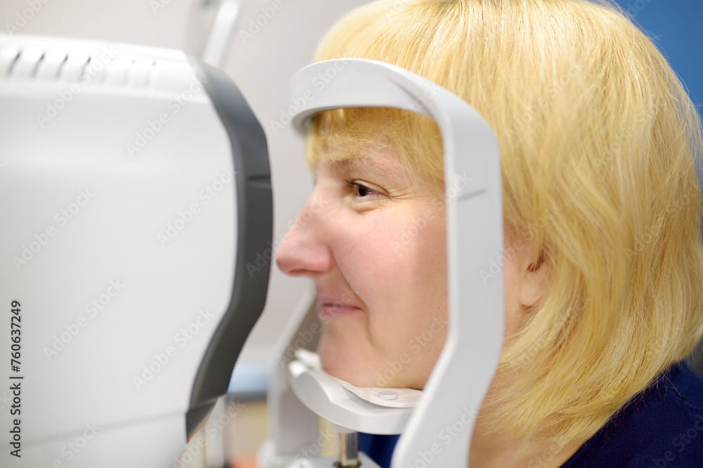 Portrait of mature woman during visit to optometrist for microscopic ...