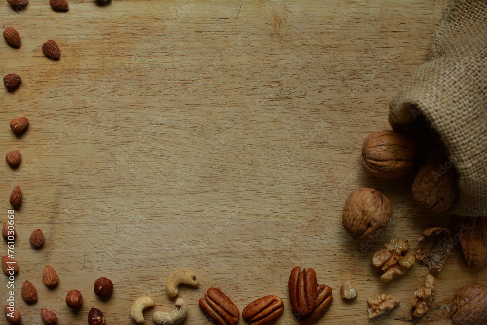 Tabla con frutas secas, madera lisa, arpillera, nueces, nuez pecán ...