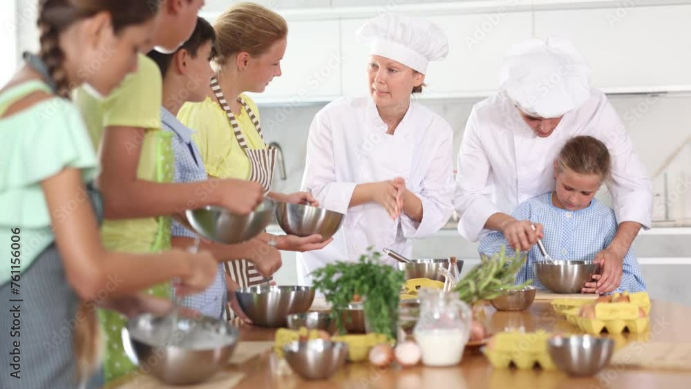 Amiable woman and young man, skilled chefs wearing white cook jackets ...