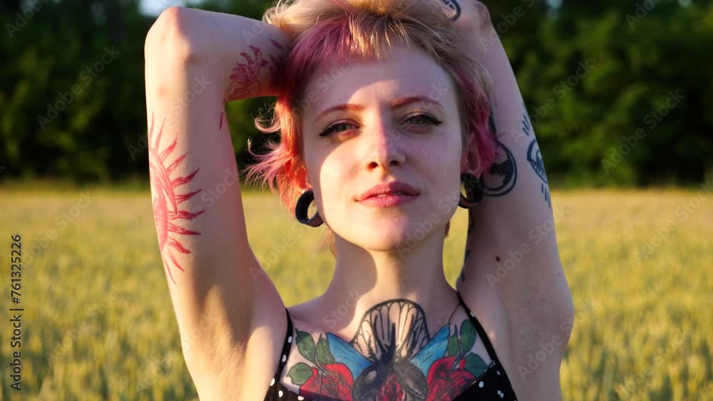 Portrait of happy punk girl with pink hair with blurred wheat green ...