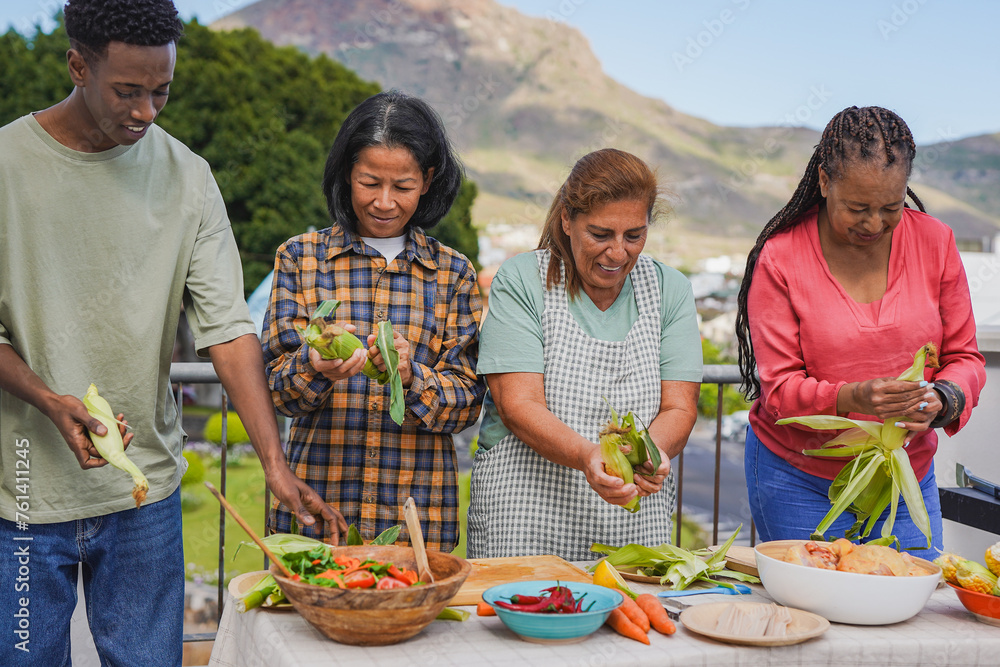 Multiracial friends preparing corn cob food for barbecue dinner - Multi ...