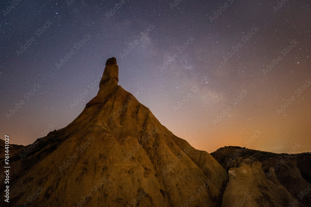 Under the star-studded night sky, the Milky Way galaxy emerges, casting ...