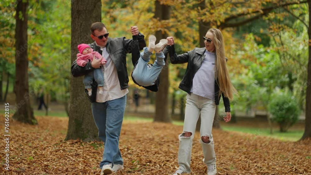 Joyful Family Moment With Playful Jump in Autumn Park. A playful leap ...