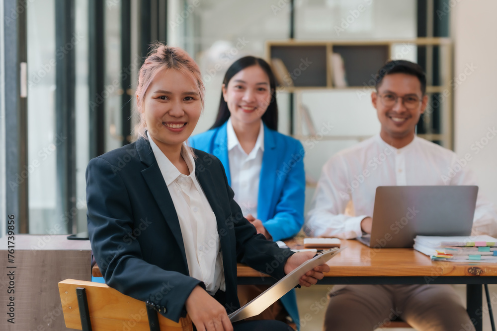 Professional business team with two women and one man in office setting ...