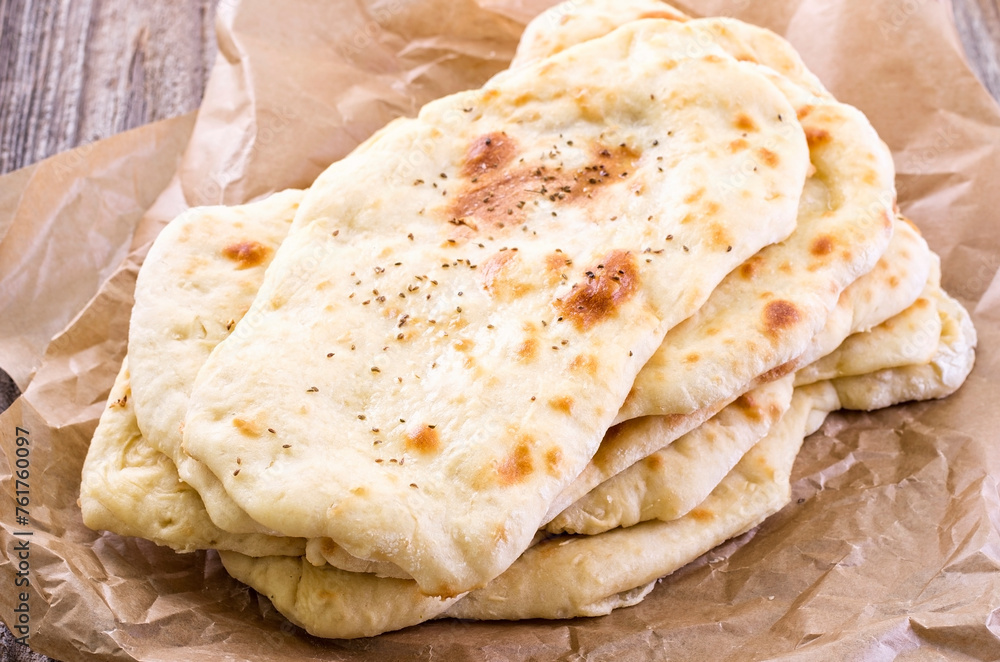 Traditional Indian chapati bread served as stack on a brown backing ...
