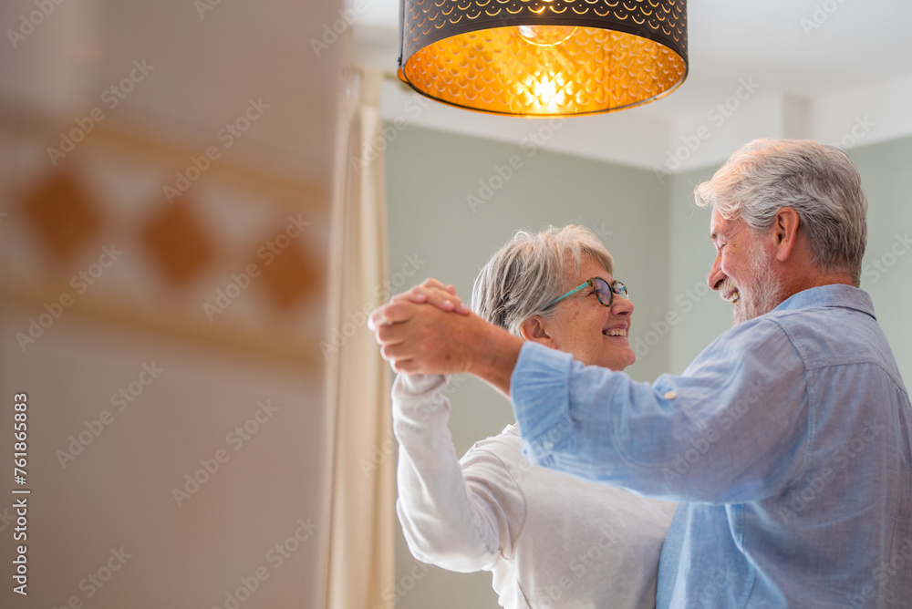 Joyful active old retired romantic couple dancing laughing in living ...