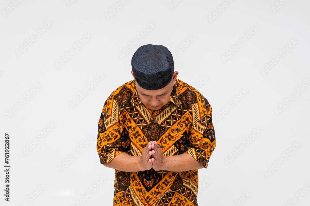 Humble and respectful Indonesian man in batik shirt and kopiah hat ...
