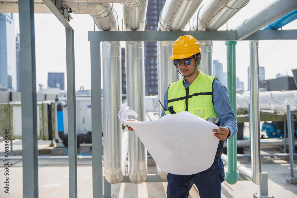 Male operator worker reading blueprint checking drawing plan cooling ...