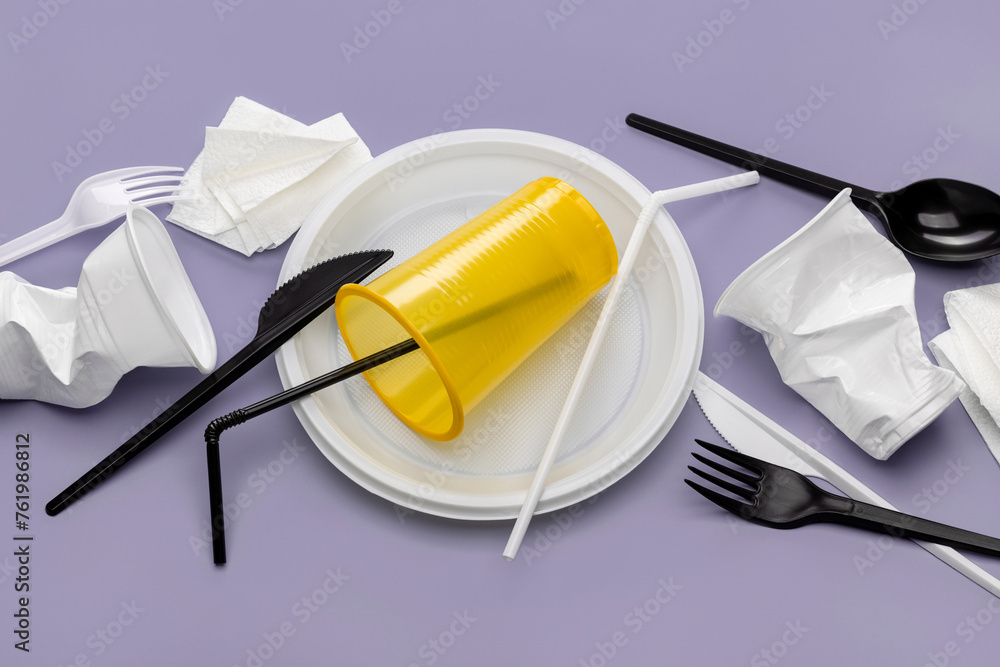 Used plastic utensils, crumpled disposable cups and paper napkins on a ...