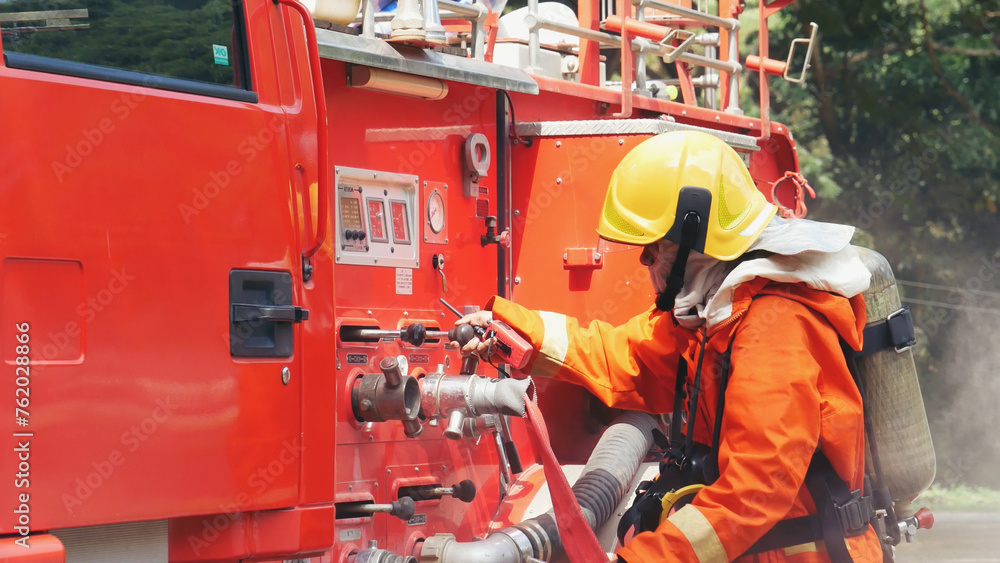 Fireman prepare equipment fighting extinguisher at fire engine truck ...