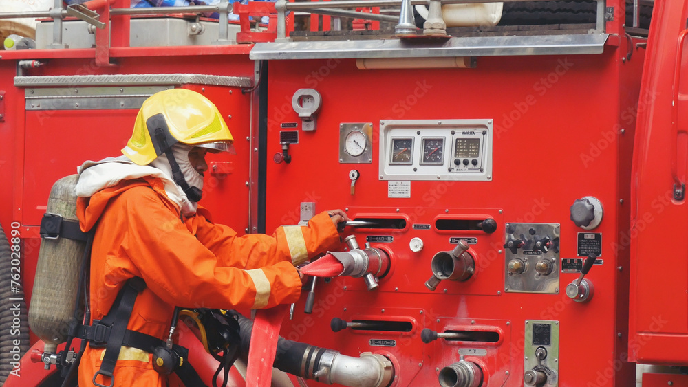 Fireman prepare equipment fighting extinguisher at fire engine truck ...