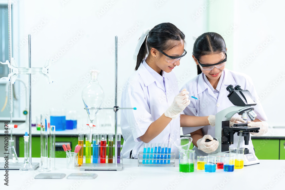 Cell experiment with microscope in chemistry lab of 2 Asian female ...