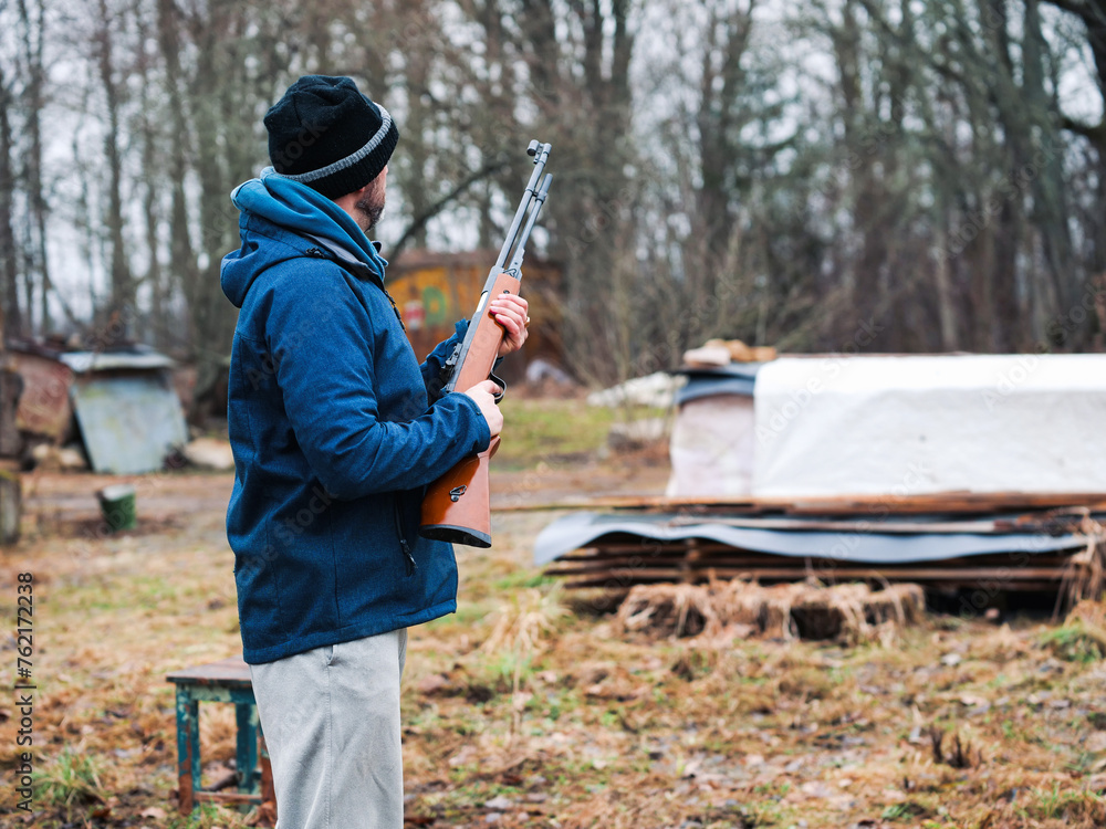 Man with old style rifle with wooden base and stock and simple iron ...