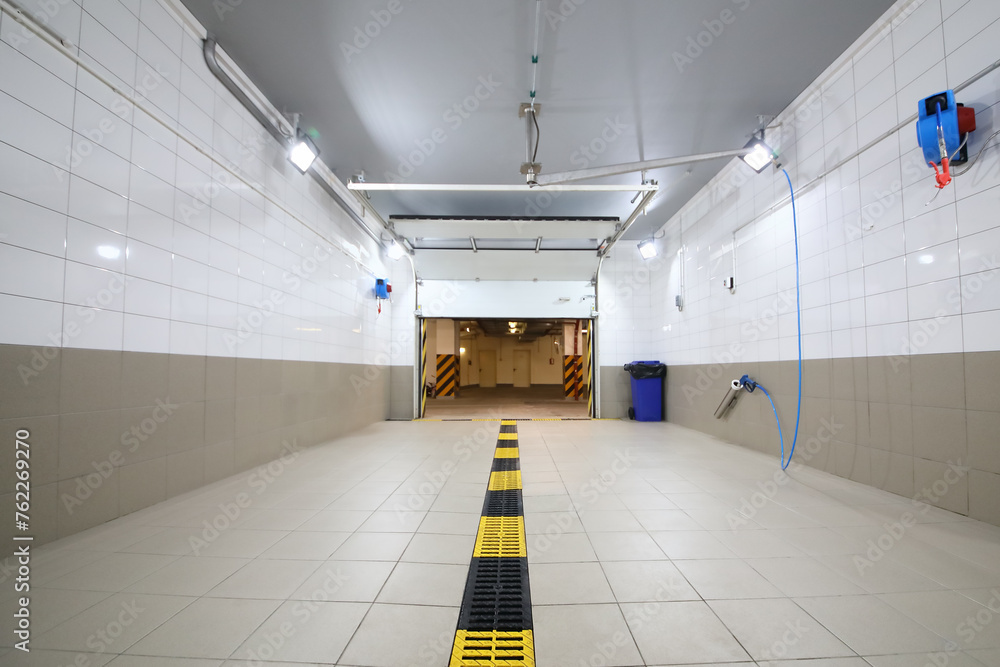 Empty clean car wash room with drainage device and open lifting gate ...