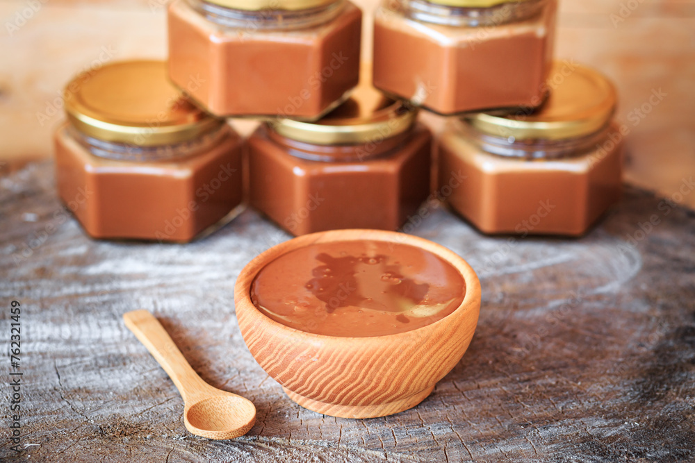 Boiled, condensed milk in a wooden plate, close-up against the ...