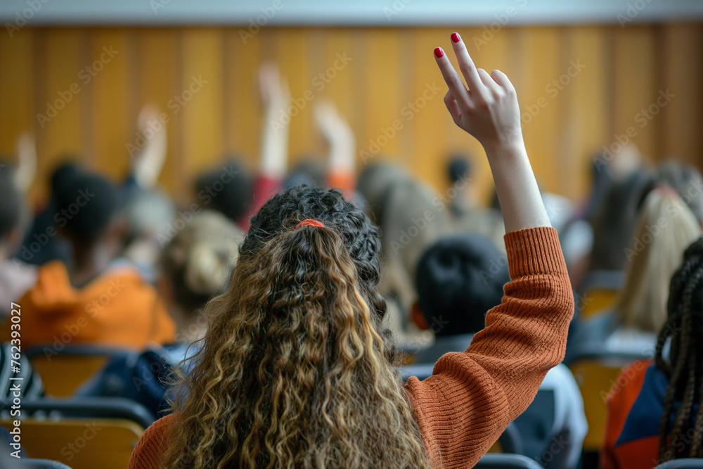 Students raising hands in class participation. Diverse group of ...