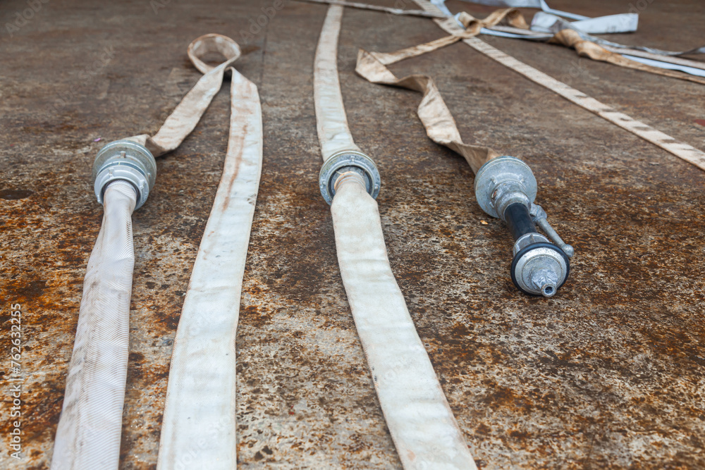 Unwound fire hoses with fire extinguishing tips. Stock Photo | Adobe Stock