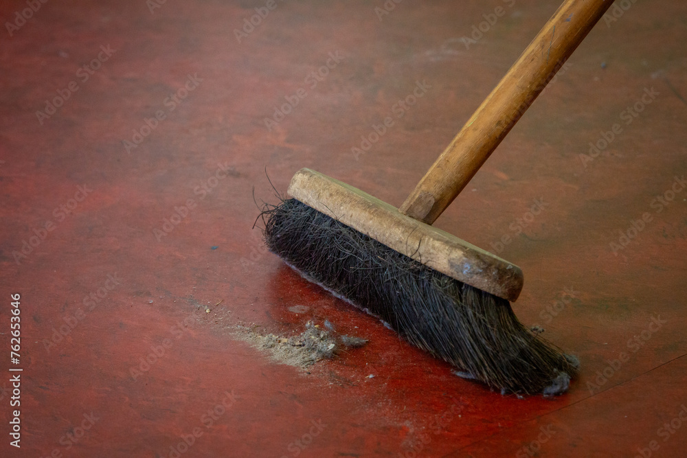 Dust on the floor being swept away with a brush or broom, Image shows a ...