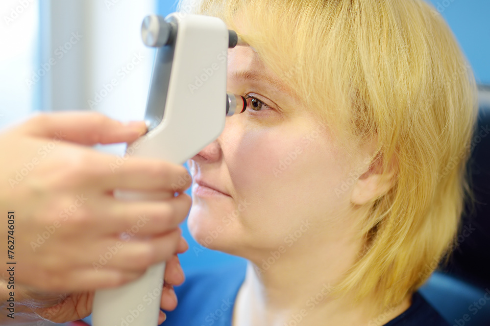 Patient during visit to optometrist. Ophthalmologist measuring the eye ...