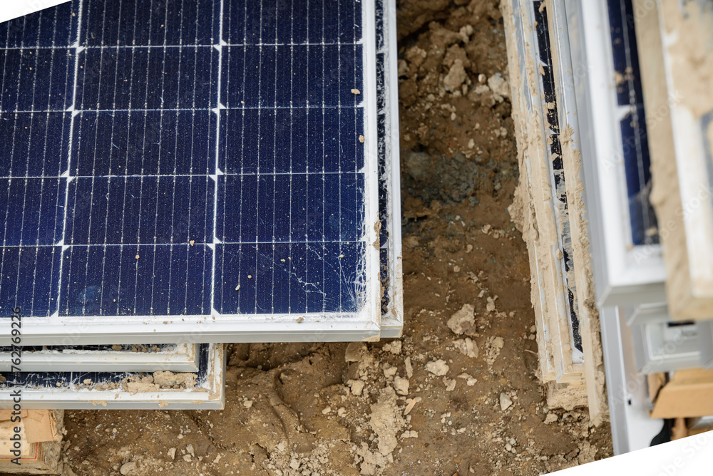 Damaged and cracked solar panels with fractured glass lie stacked on ...