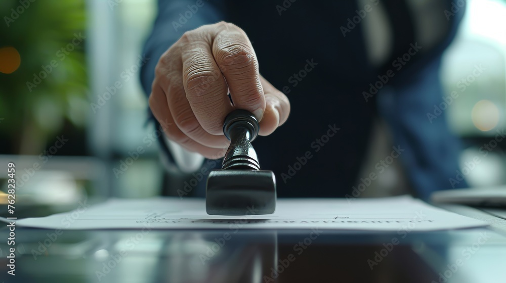 A close-up capturing the moment a document is officially approved with ...