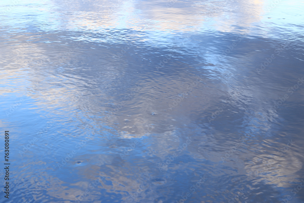 Reflection of clouds in water. The surface of water in a lake, river or ...
