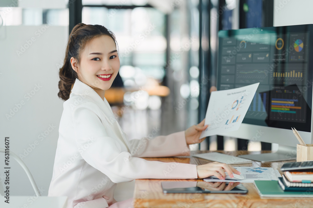 Professional data analyst using data visualizations dashboard on computer monitor for data ...
