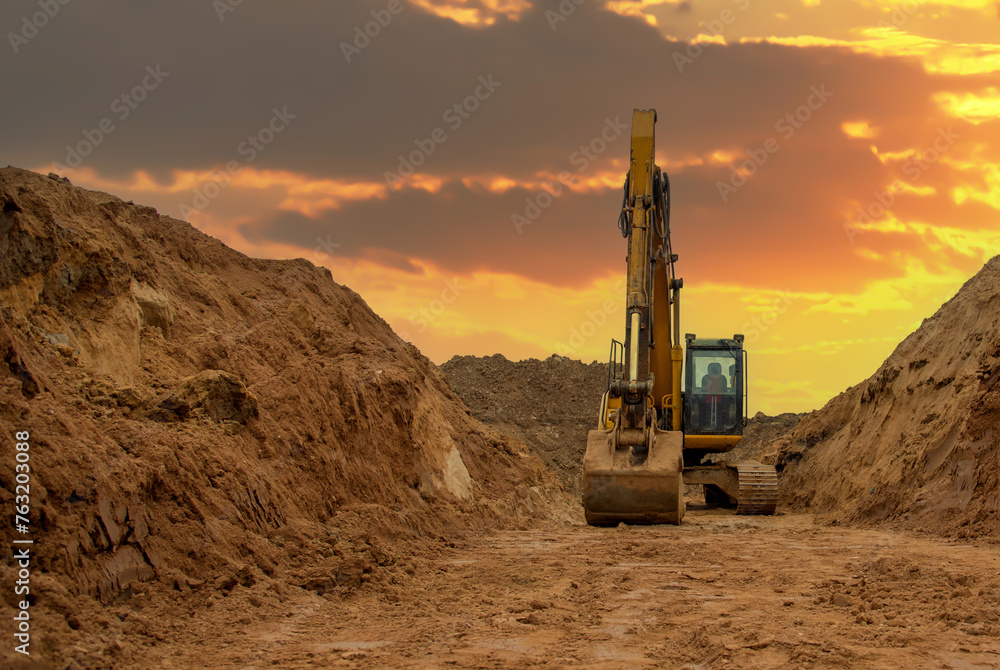 Excavator digs a large trench for pipe laying. Backhoe during ...