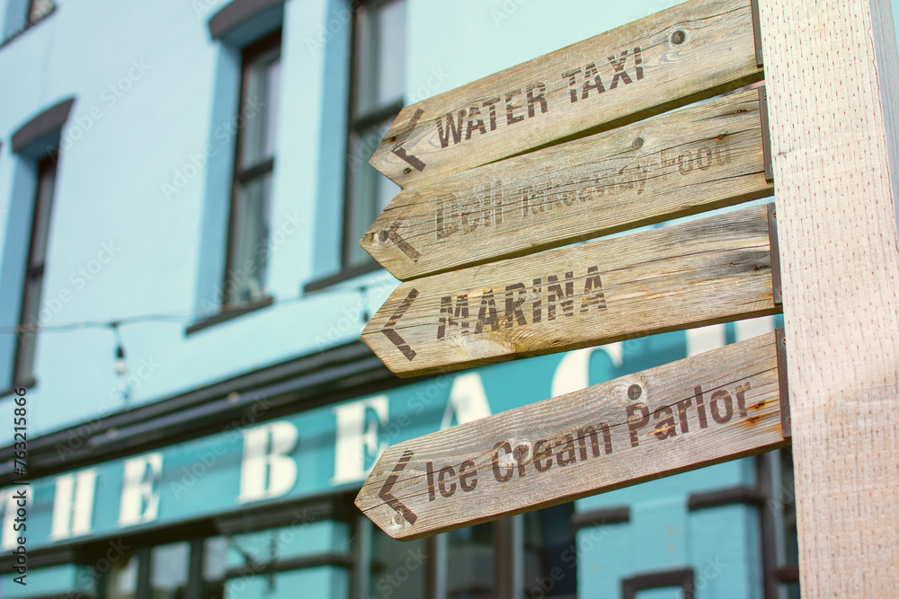 Beach and holiday concept image. A wooden signpost points to various ...