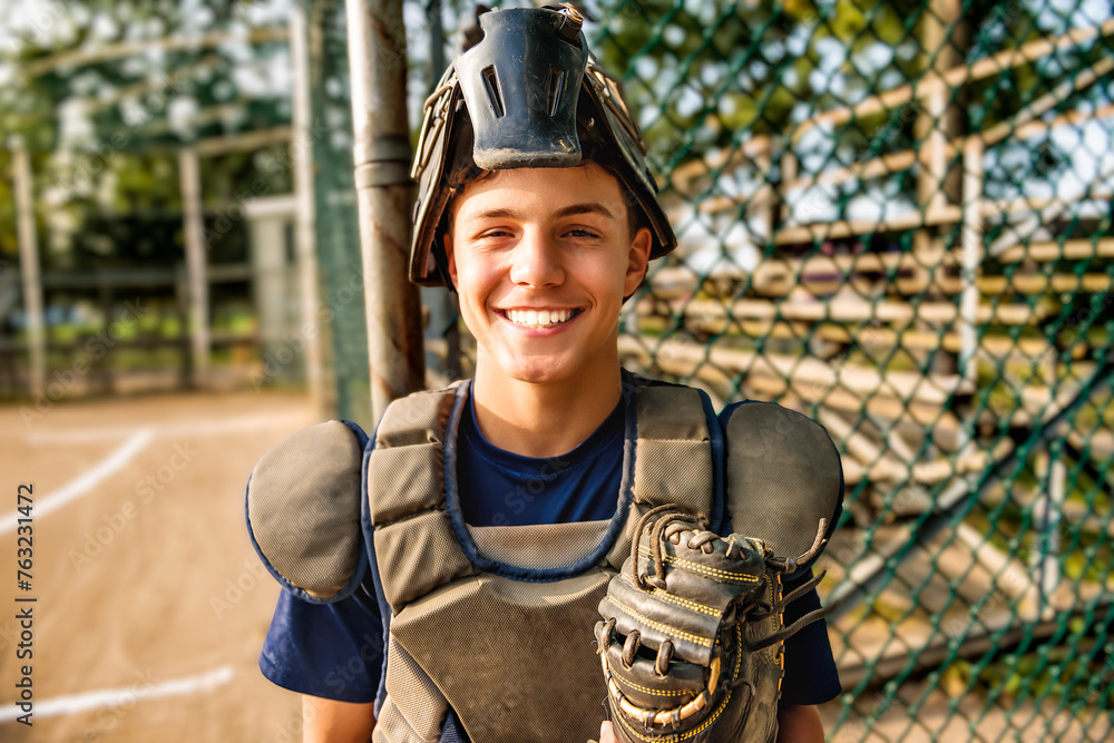 Young teen boy play baseball on a playground wearing catcher clothes ...