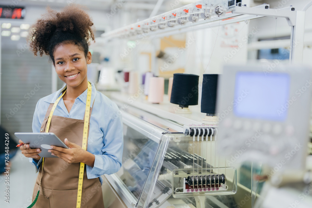 American designer female seamstress stands near weaving machine ...