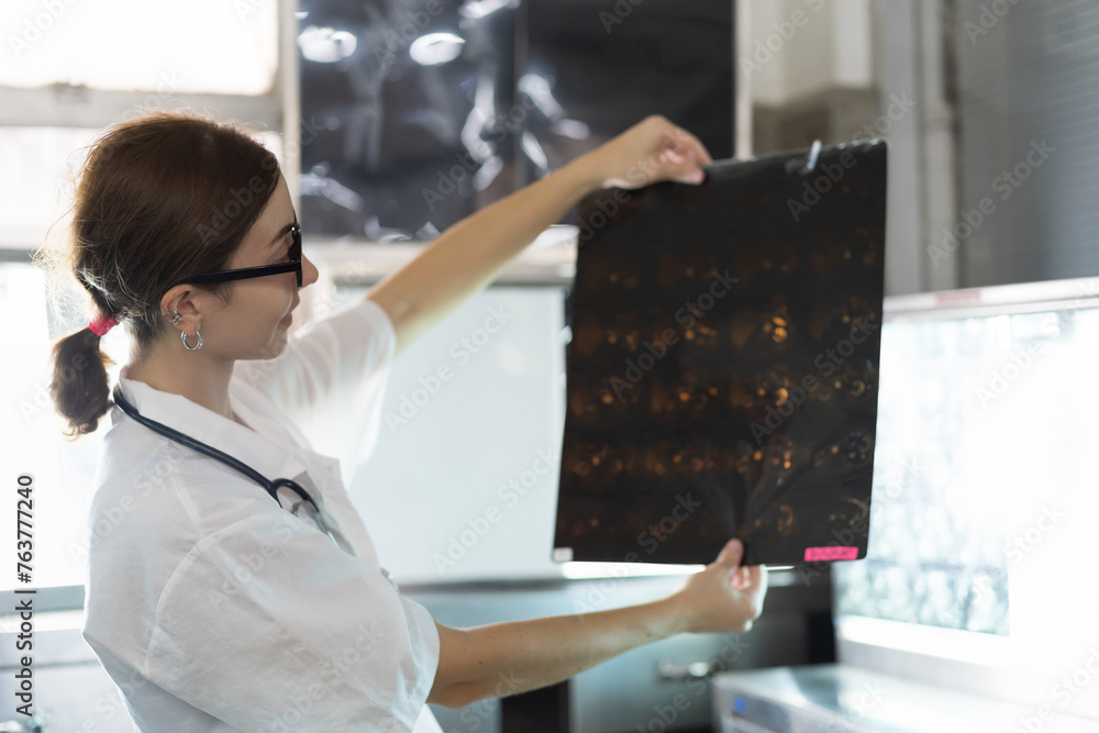 Female doctor checking anatomy and physiology x-ray film of patient in ...