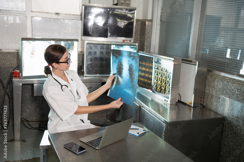 Female doctor checking anatomy and physiology x-ray film of patient in ...