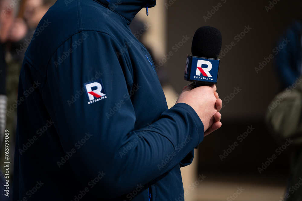 Reporter holding microphone with logo sign of Telewizja Republika ...