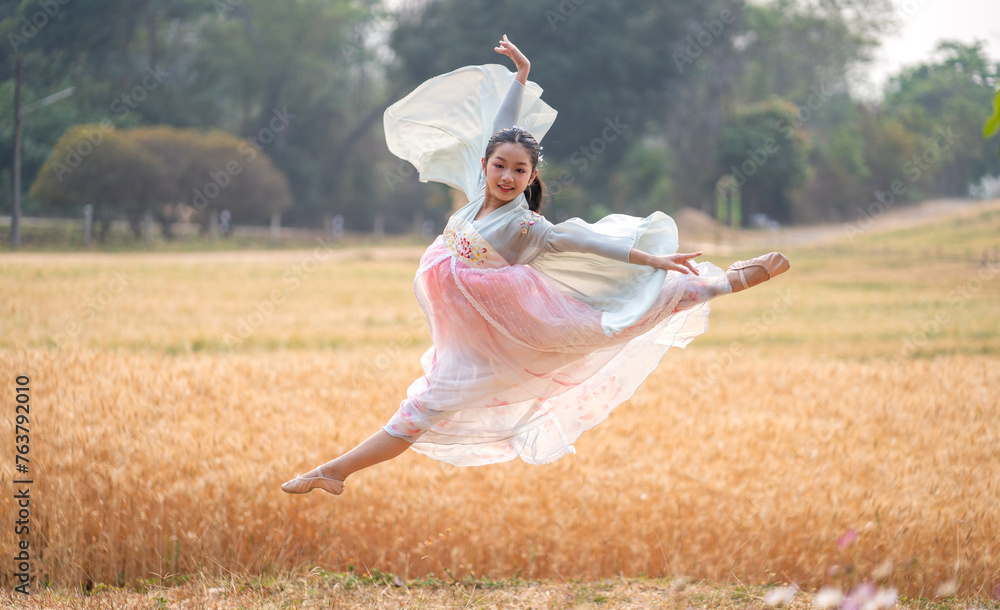 Flying dancer in the air. Happy Asian girl ballerina in a Chinese ...