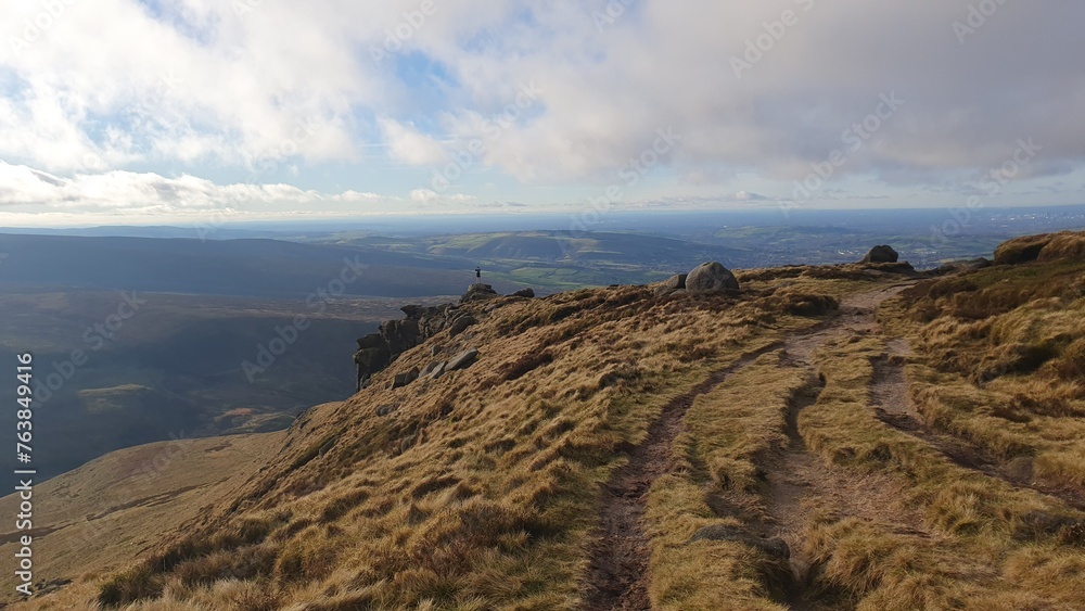 grassy hill top with two small stone piles and a view into the ...
