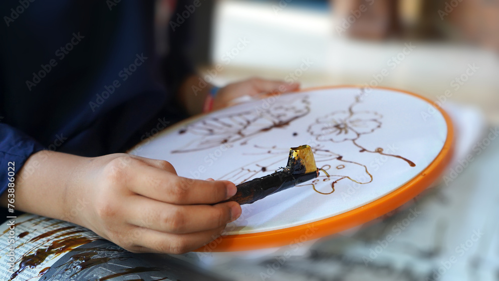 Batik making process, a handmade traditional art from Indonesia. Person ...
